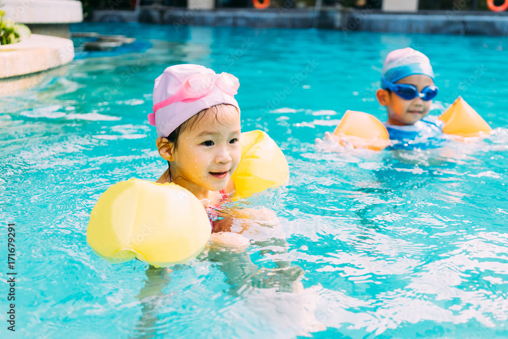 Two kids playing in swimming pool Stock Photo | Adobe Stock