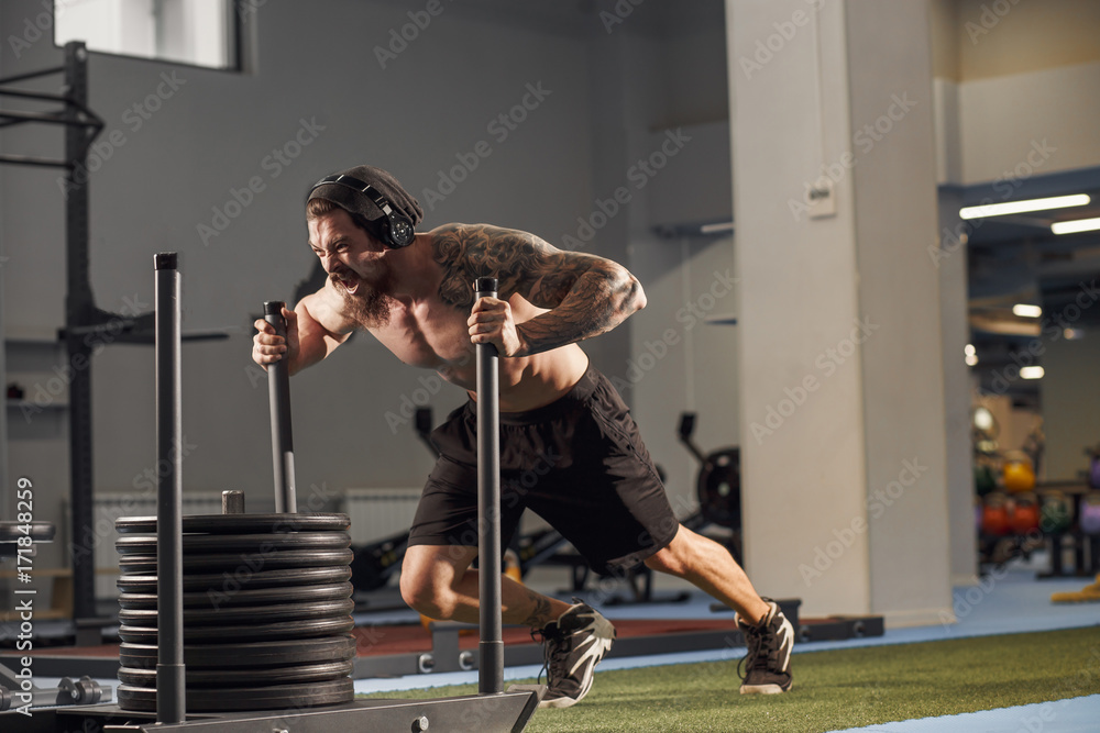 sled push man pushing weights workout exercise at gym Stock Photo ...