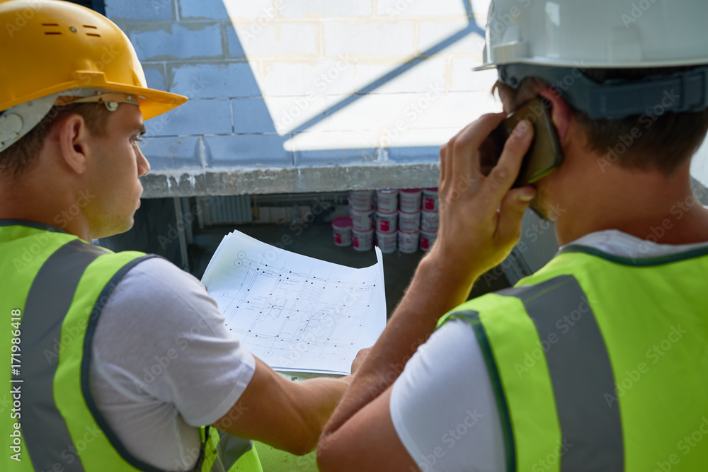 Back view of unrecognizable construction workers wearing reflective ...