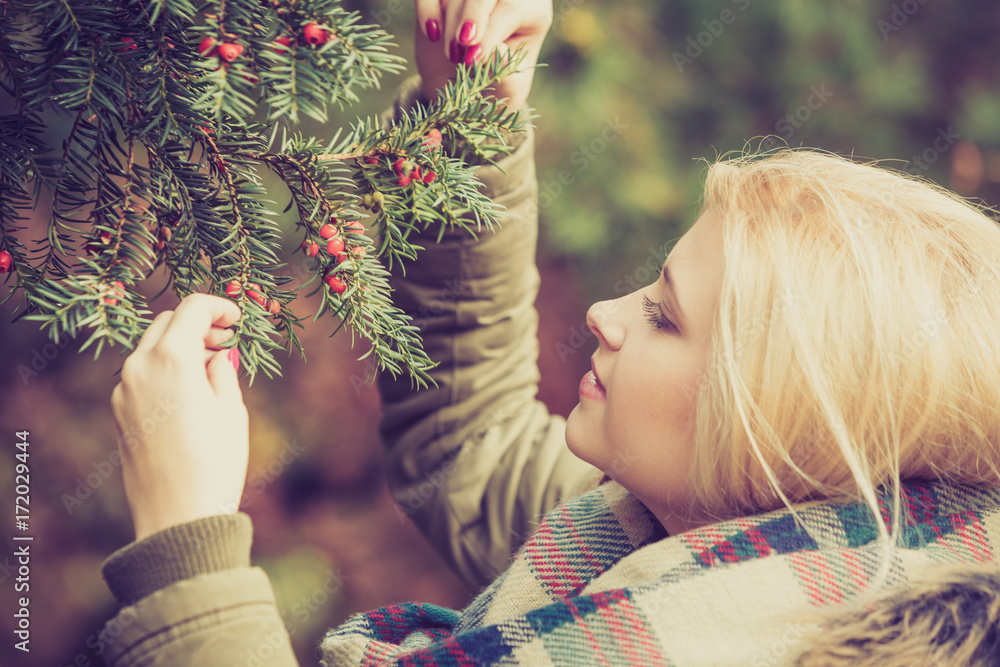 Woman dressed warmly looking at bush Stock Photo | Adobe Stock