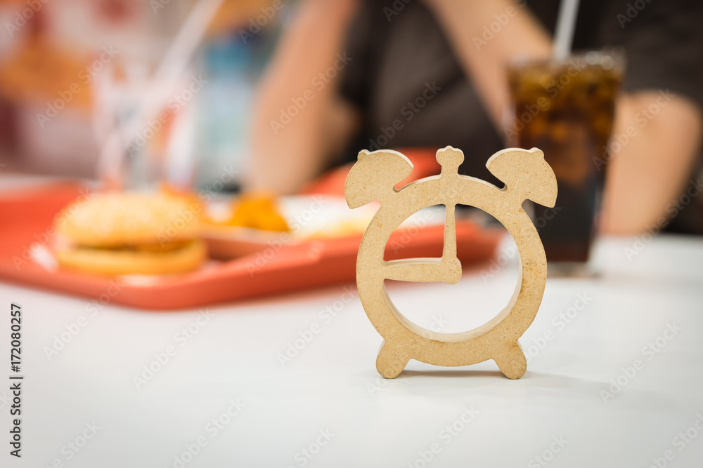 Wooden clock model put on the white table of Fast food restaurant with ...
