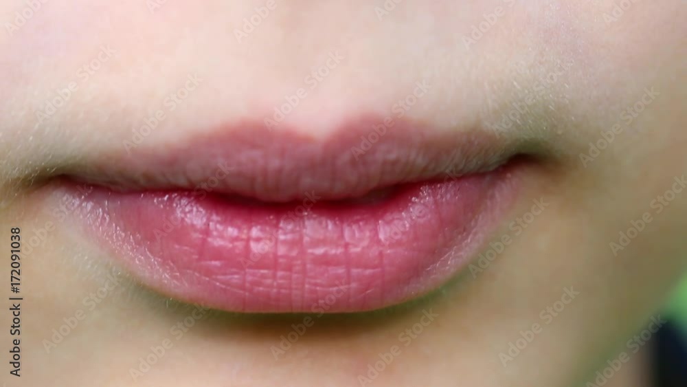 Closeup view of cute pink lips of young caucasian boy moving while he ...
