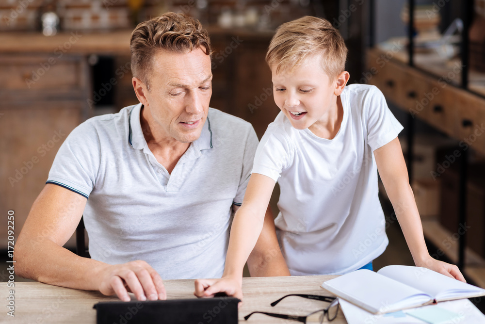 Foto de Pre-teen boy explaining father how to use tablet do Stock ...