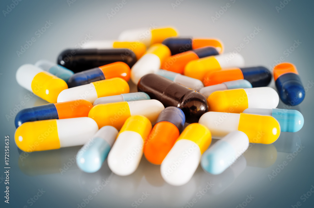Pharmacy theme. Orange, Yellow, Blue, White Isolated Capsules on the ...