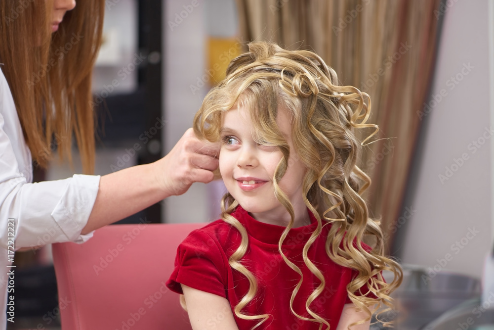 Smiling little girl, hair salon. Caucasian child at the hairdresser ...