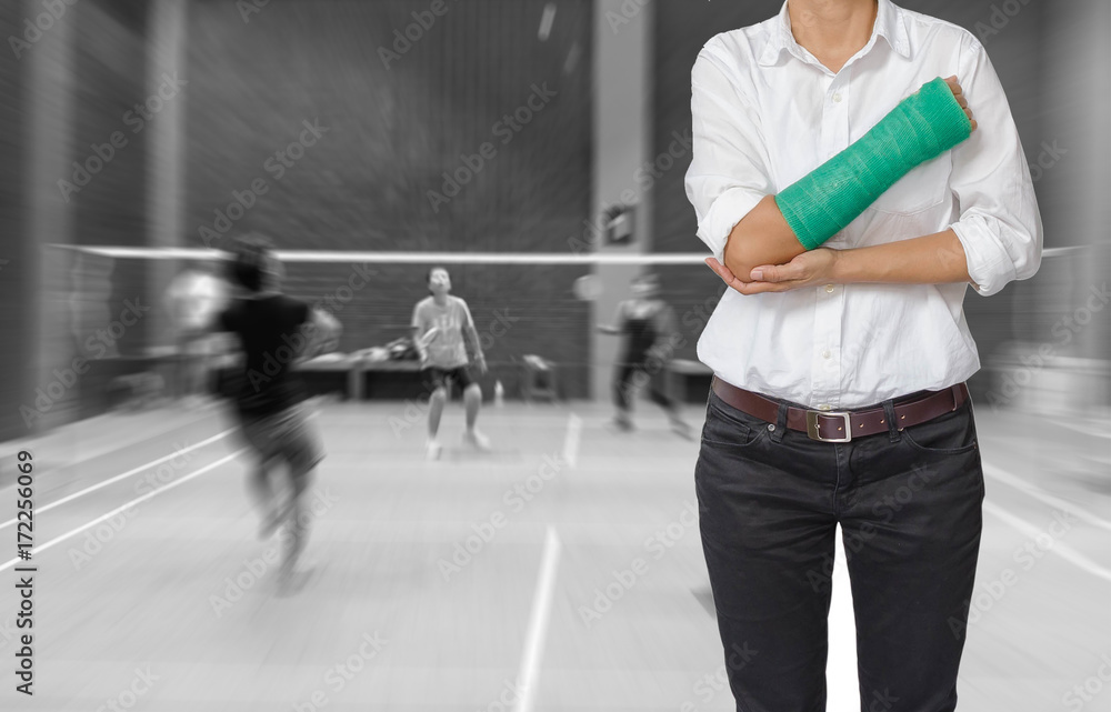 Injured woman with green cast on hand and arm isolated on blurred ...