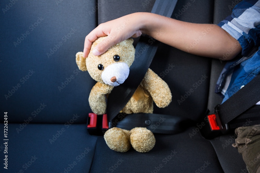 Teenage boy sitting with teddy bear in the back seat of car Stock Photo ...