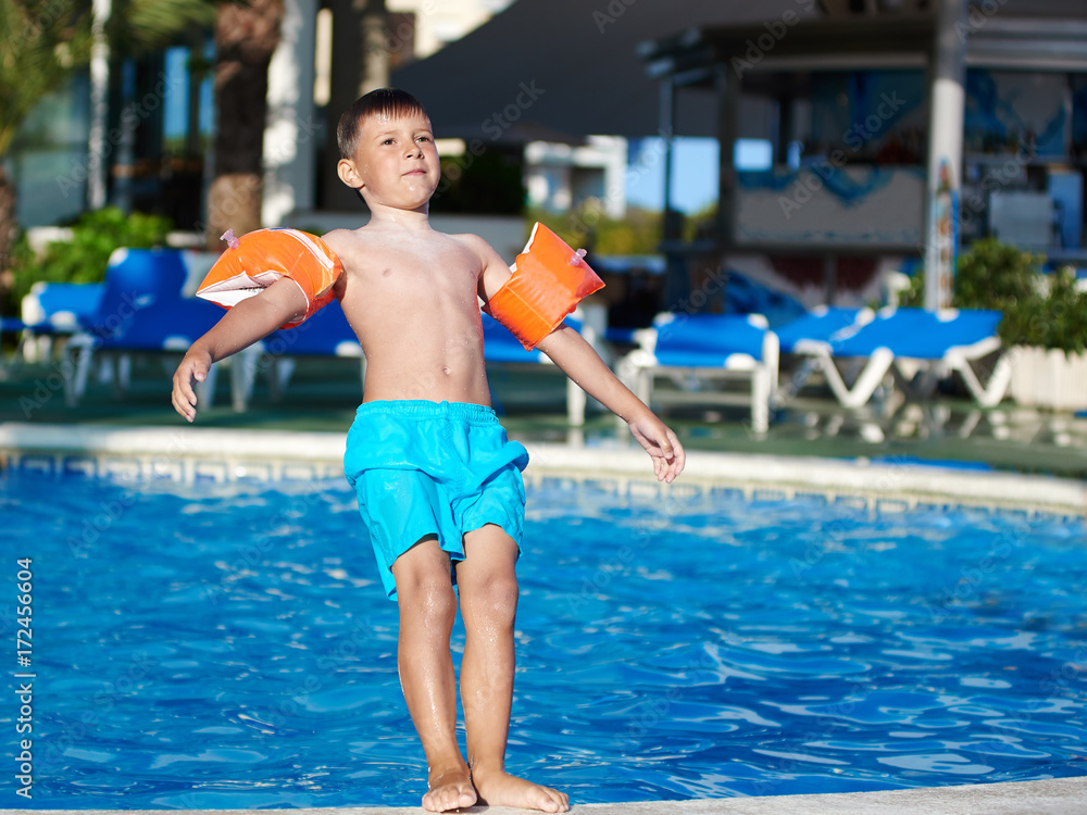 Cute caucasian boy making fake falling into the the swimming pool ...