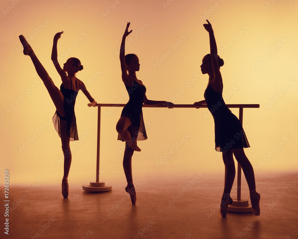 Composition from silhouettes of three young dancers in ballet poses on ...