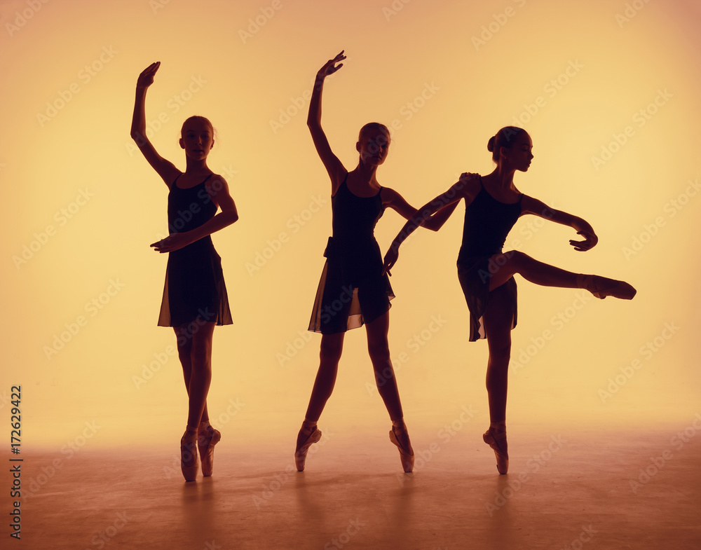 Composition from silhouettes of three young dancers in ballet poses on ...