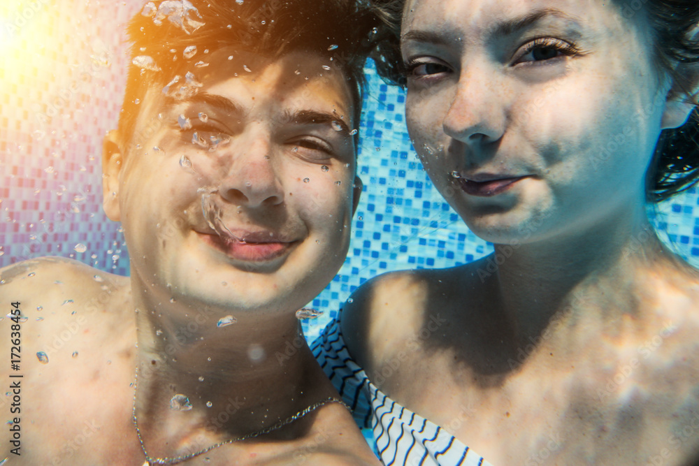 Happy couple in love under water. Smiling boy and girl making selfie in ...