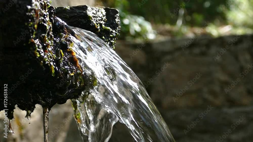 Close-up of the spout of a mountain fountain with crystalline, pure and ...