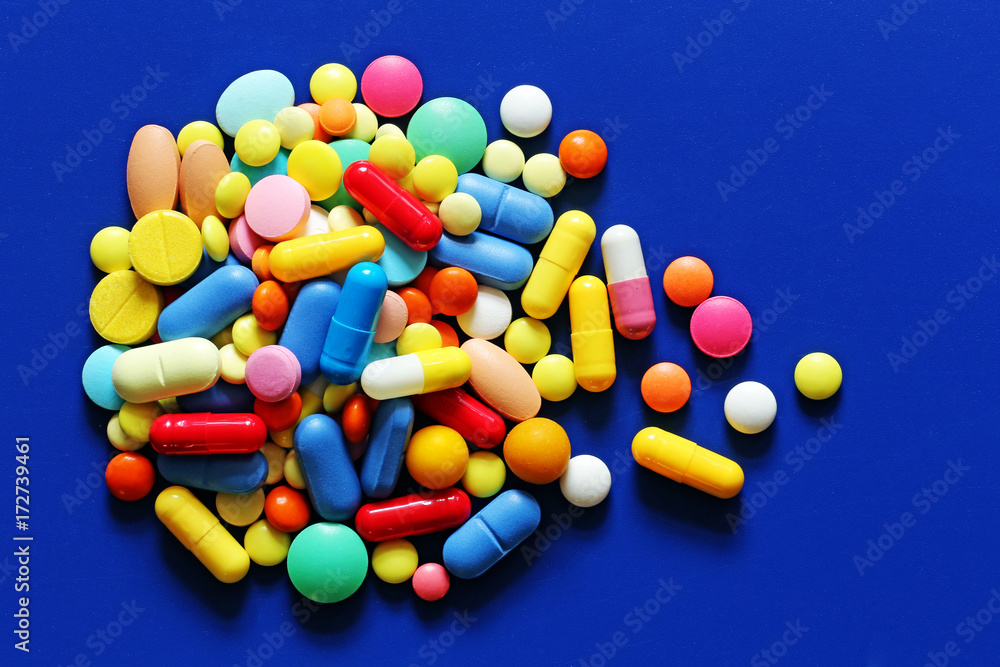 Colorful pills on a blue background Stock Photo | Adobe Stock