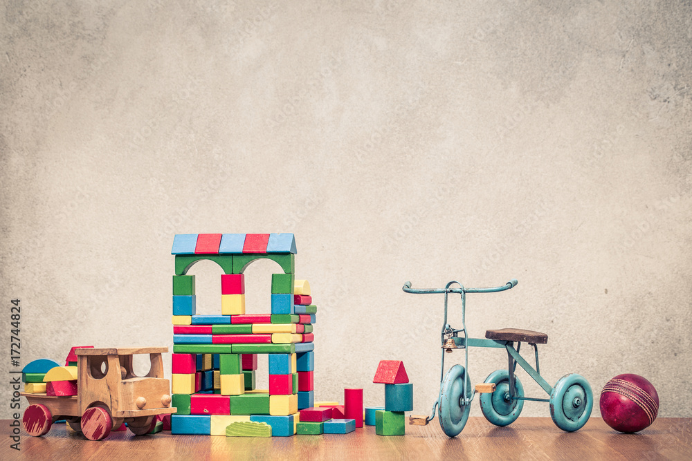 Retro old toys: wooden house made of construction blocks, truck, trike ...