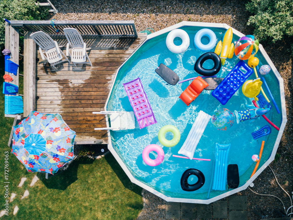 Overhead drone image of an above ground pool filled with pool floats ...