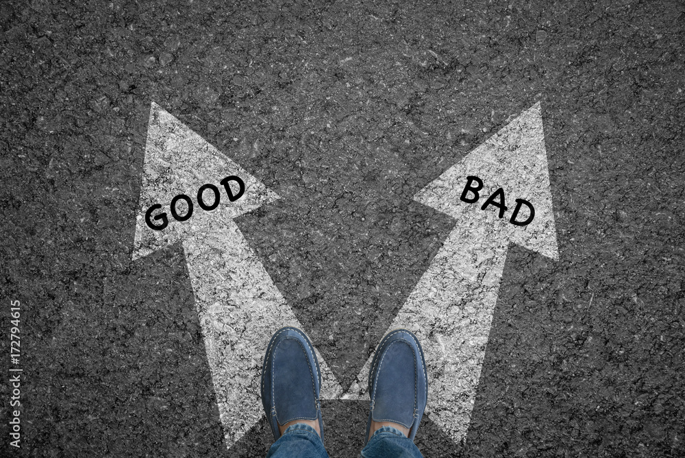 man standing on road with direction arrow choices Good and Bad or move ...