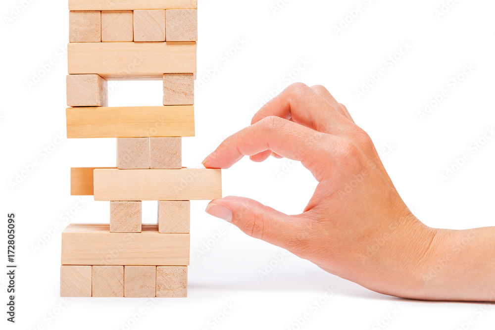 The tower from wooden blocks and man's hand take one block Stock Photo ...
