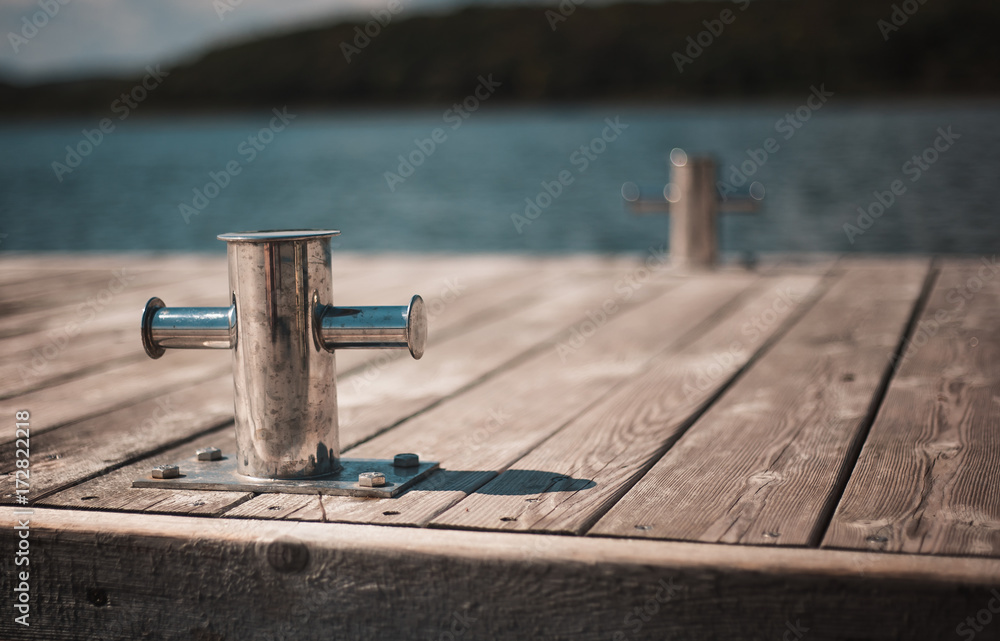 Magnificent view of the sea wooden pier with mirror bollard and mooring ...