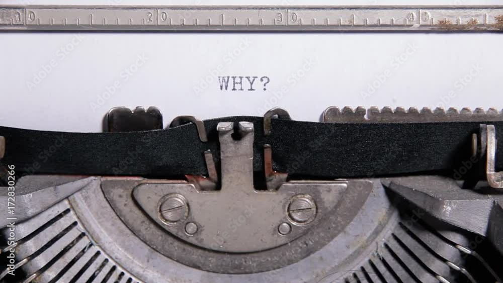 Typing the word - Why - with a question mark - on a sheet of paper with ...