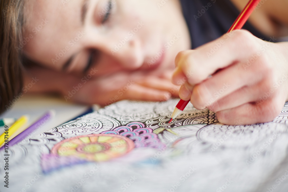 Young woman colouring in an adult colouring in book Stock Photo | Adobe ...