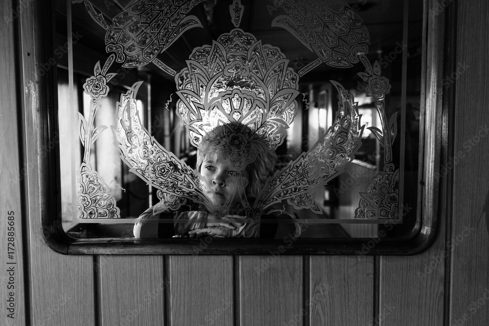 Little girl behind an engraved window. Stock Photo | Adobe Stock