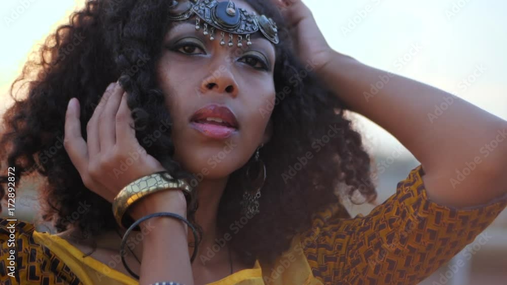 Portrait of young afro-american gypsy woman in colorful yellow ...