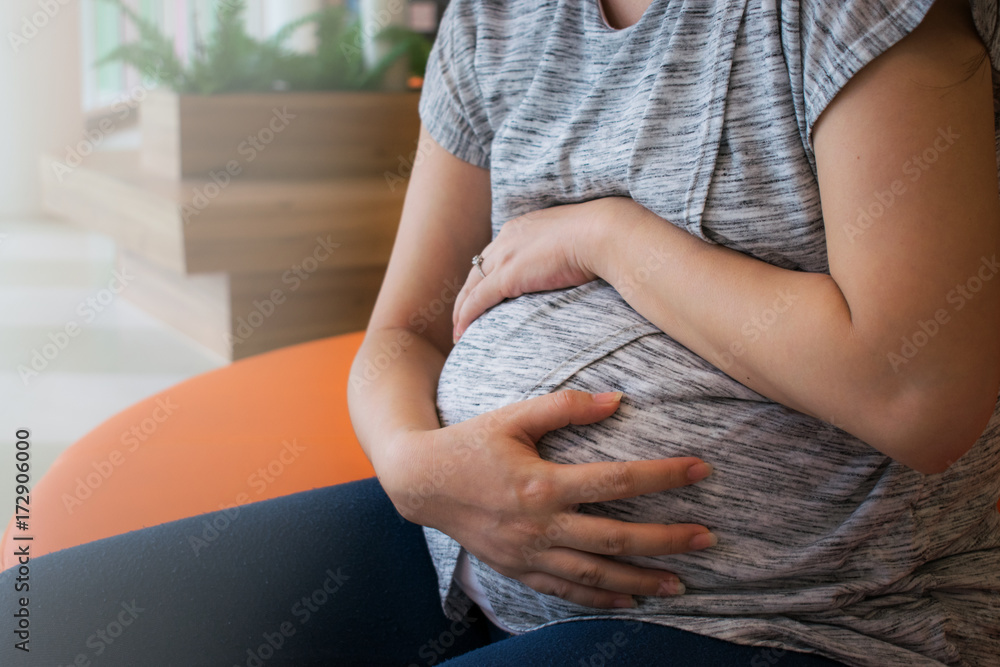Pregnancy. Pregnant woman is touching her belly with hands. Abdominal ...
