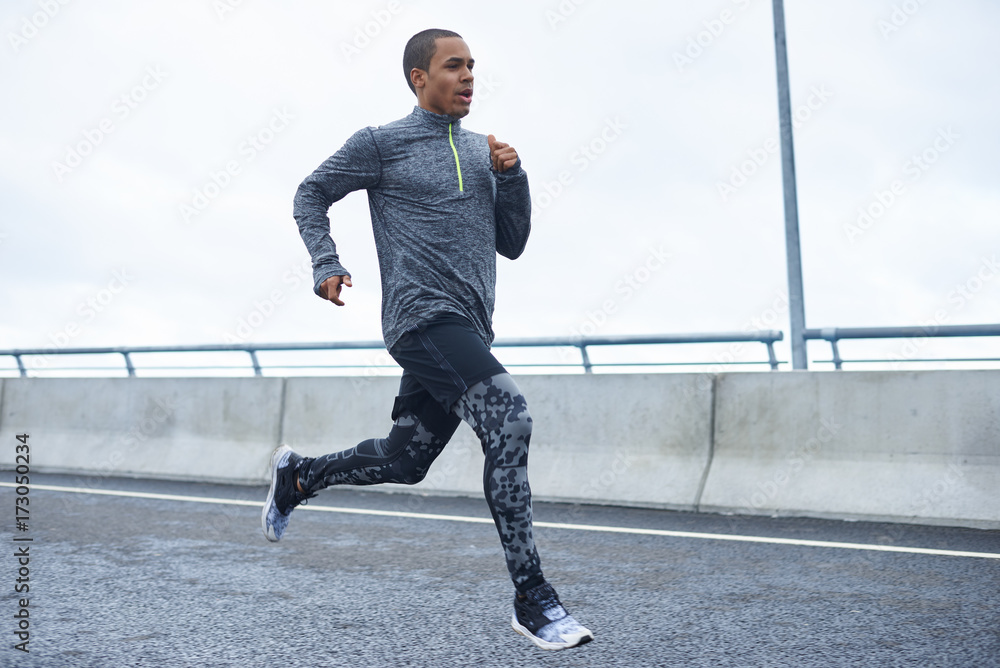 Freeze action shot of confident young black athletic man wearing trendy ...
