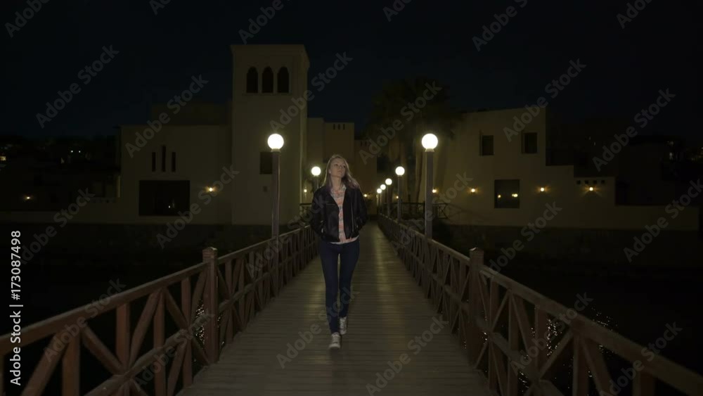 Video „Blonde young woman in leather jacket walks alone on wooden ...