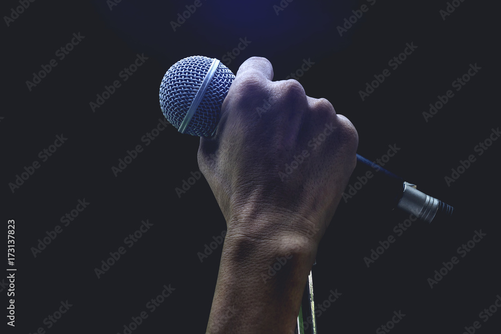 Man hands holding microphone on stand. Stock Photo | Adobe Stock