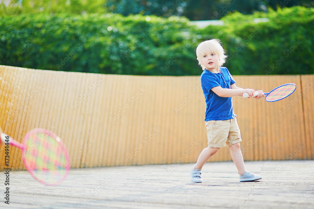 Little boy playing badminton on the playground Stock Photo | Adobe Stock