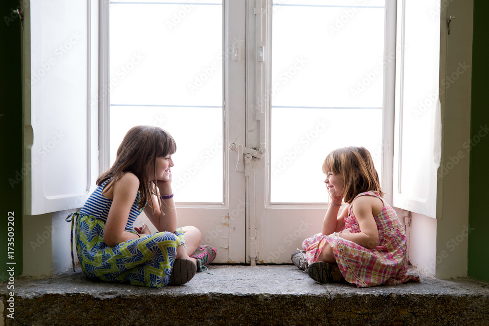 Two little girls in front of a window Stock Photo | Adobe Stock