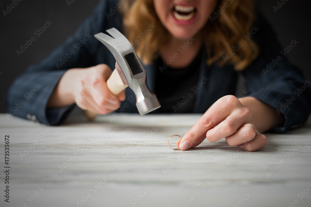 Angry woman smashing wedding ring Stock Photo | Adobe Stock