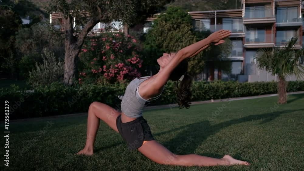 Woman on lawn makes a deflection back standing in attack on one leg ...