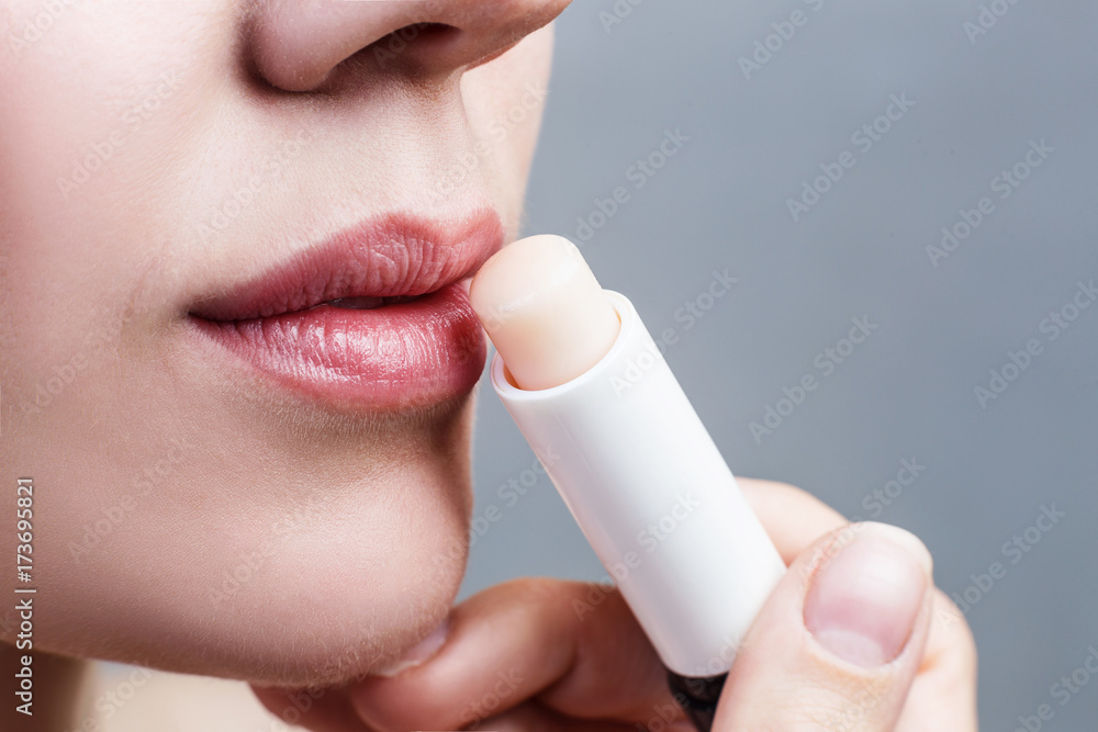 Beautiful woman applying hygienic lip balm. Stock Photo | Adobe Stock