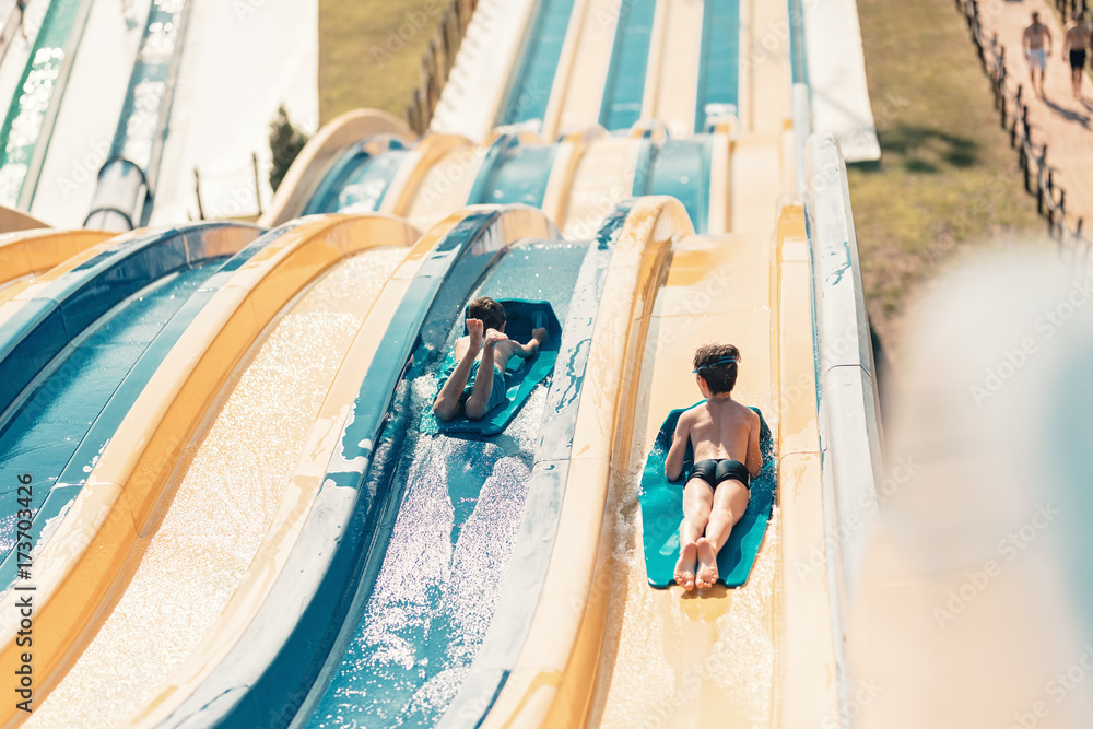 Cool people having fun on the water slide with friends and familiy in ...
