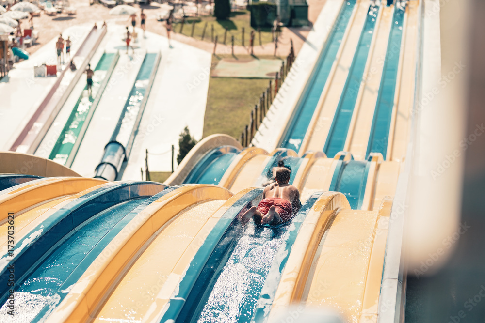 Cool people having fun on the water slide with friends and familiy in ...