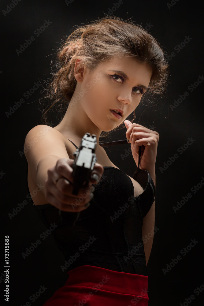beautiful young woman with black gun aiming at camera Stock Photo ...