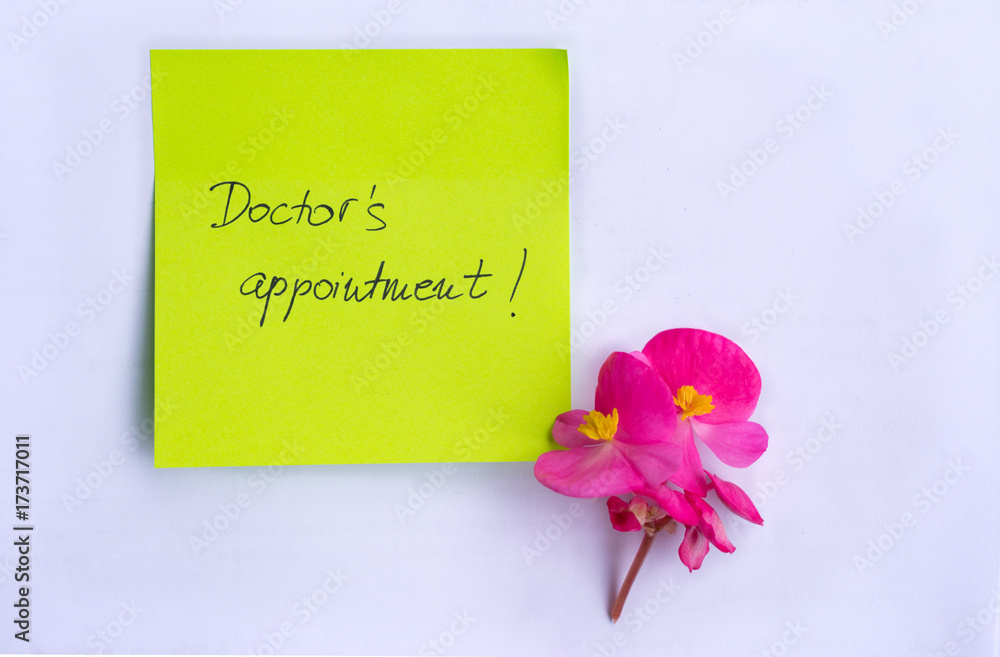 Doctor's appointment handwritten as a reminder on a yellow post it ...