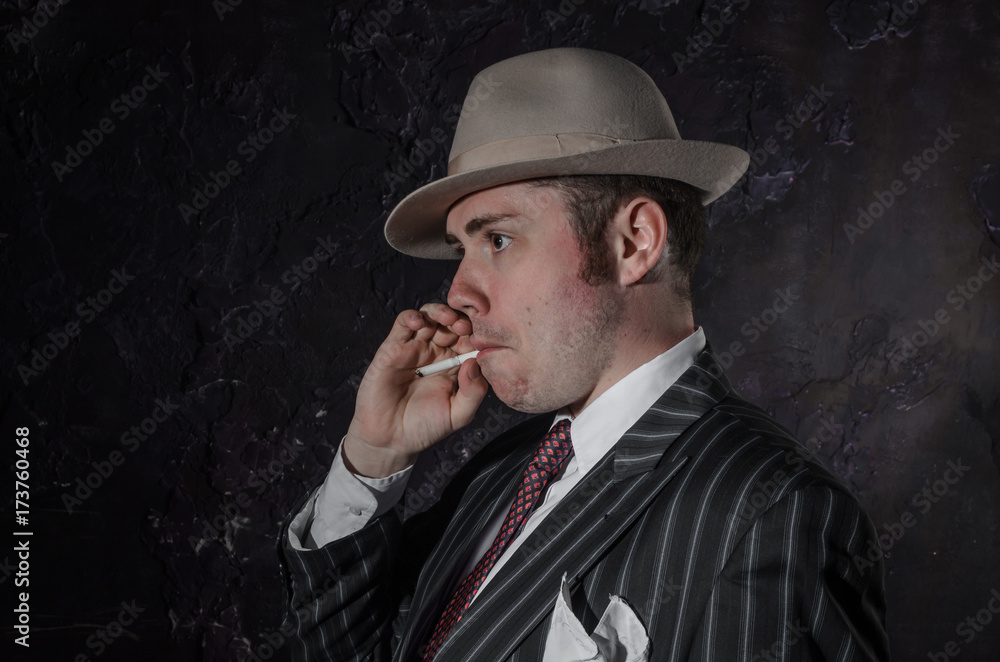 Private detective in old fashion hat smokes a cigarette. Gangster looks ...