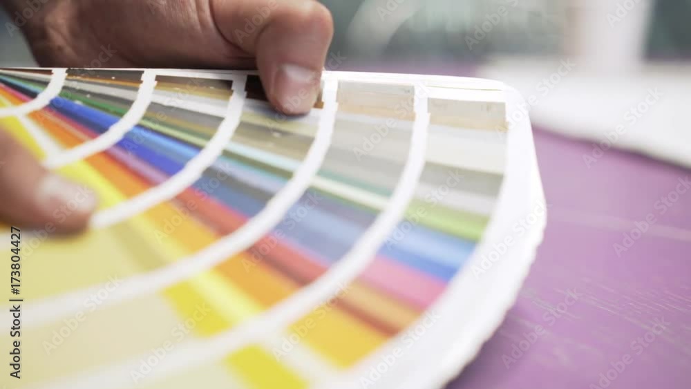 Side view of hands of an unrecognizable architect holding a color chart ...