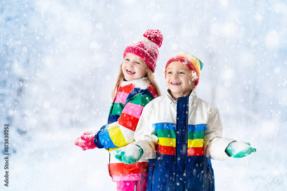 Kids playing in snow. Children play outdoors in winter snowfall. Stock ...