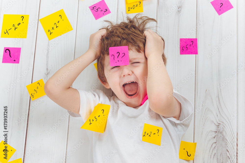 Crying child with question symbol with stickers on his head and around ...