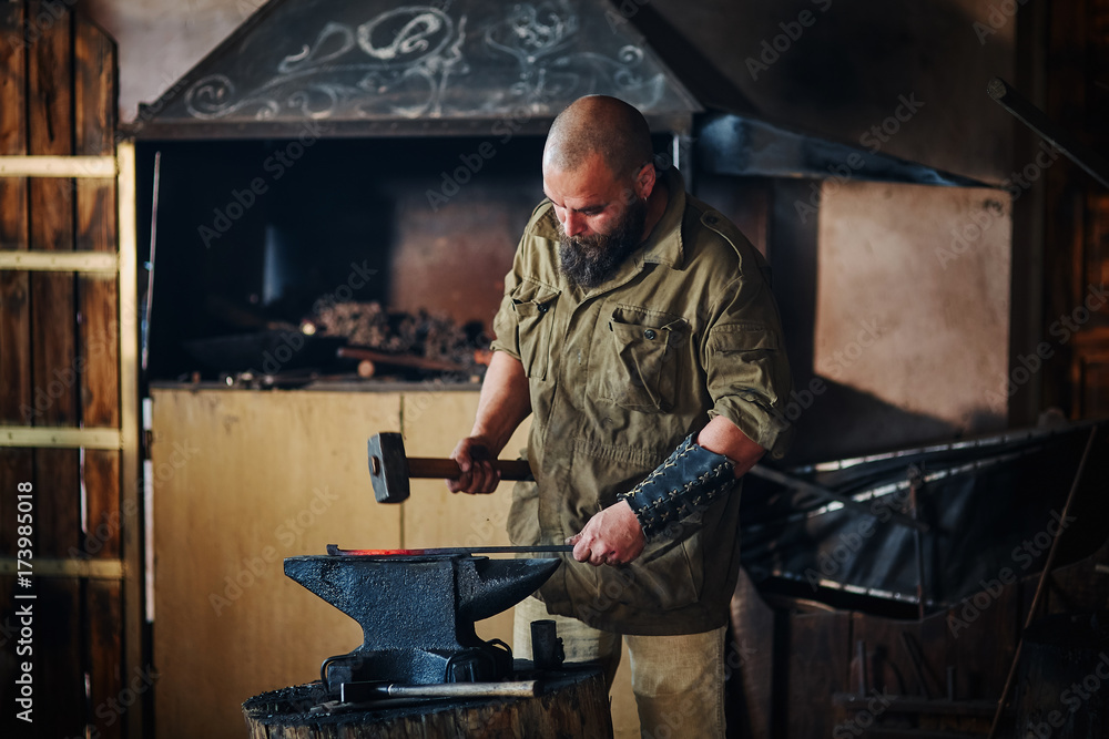 Blacksmith working in the forge. Manufacture of parts and weapons from ...