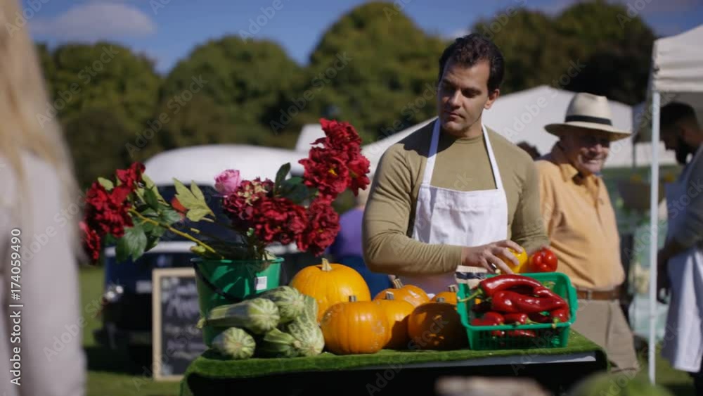 Friendly stall holders selling to customers at the farmers market Stock ...
