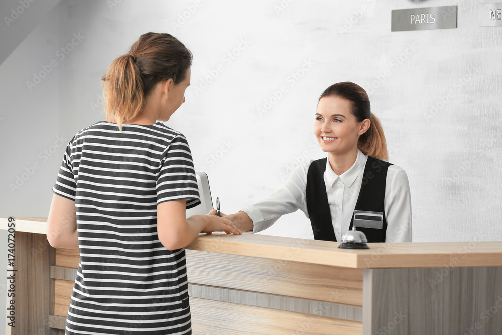 Young woman at reception desk in hotel Stock Photo | Adobe Stock