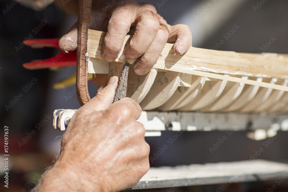 handcrafted craftwork of a wooden boat model / old man working on ...