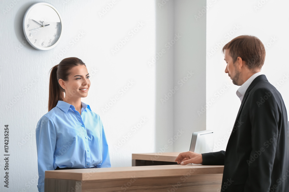 Young female receptionist meeting client in office Stock Photo | Adobe ...
