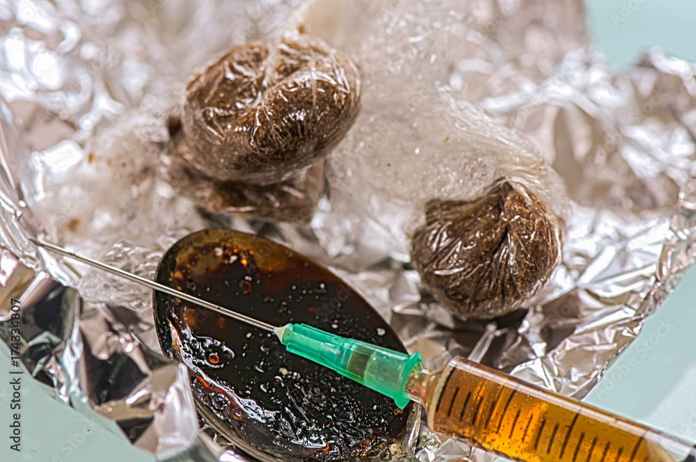 Wraps of brown drugs with a spoon and syringe on foil Stock Photo ...
