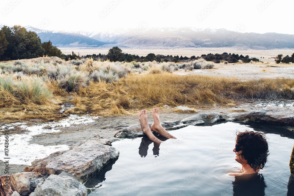 Man Relaxes in Natural Hot Spring with Mountain View and Snow Stock ...